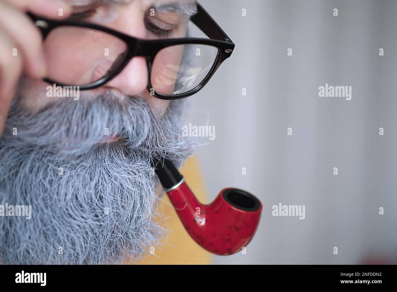 Guy smoking tobacco pipe. Hipster grey beard and mustache. Bad habits ...