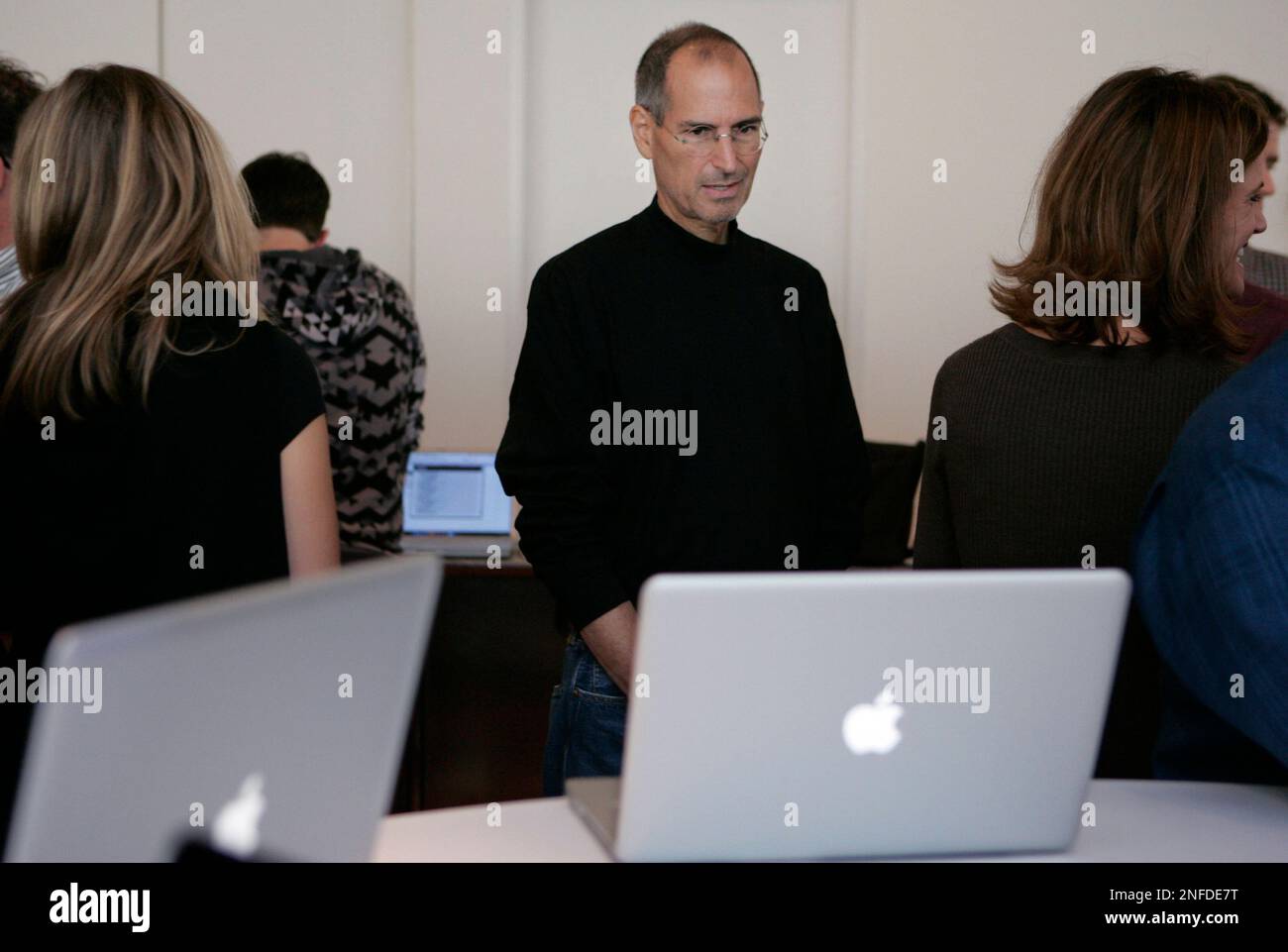 Apple CEO Steve Jobs looks at a new MacBook Pro during product ...