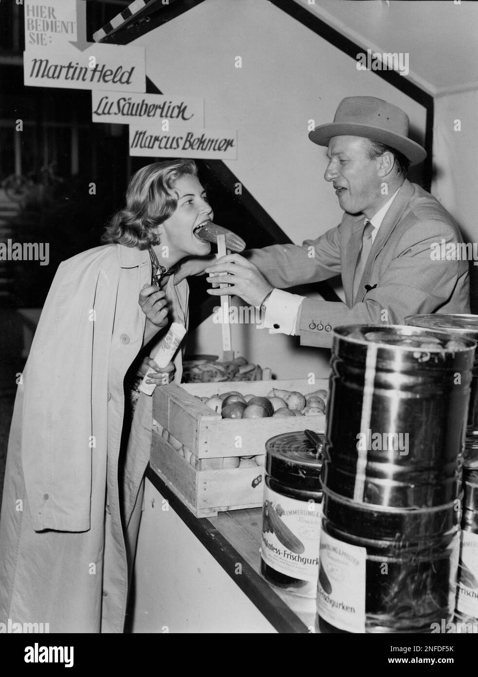 West German actor Martin Held, right, feeds a young blond dame with a ...