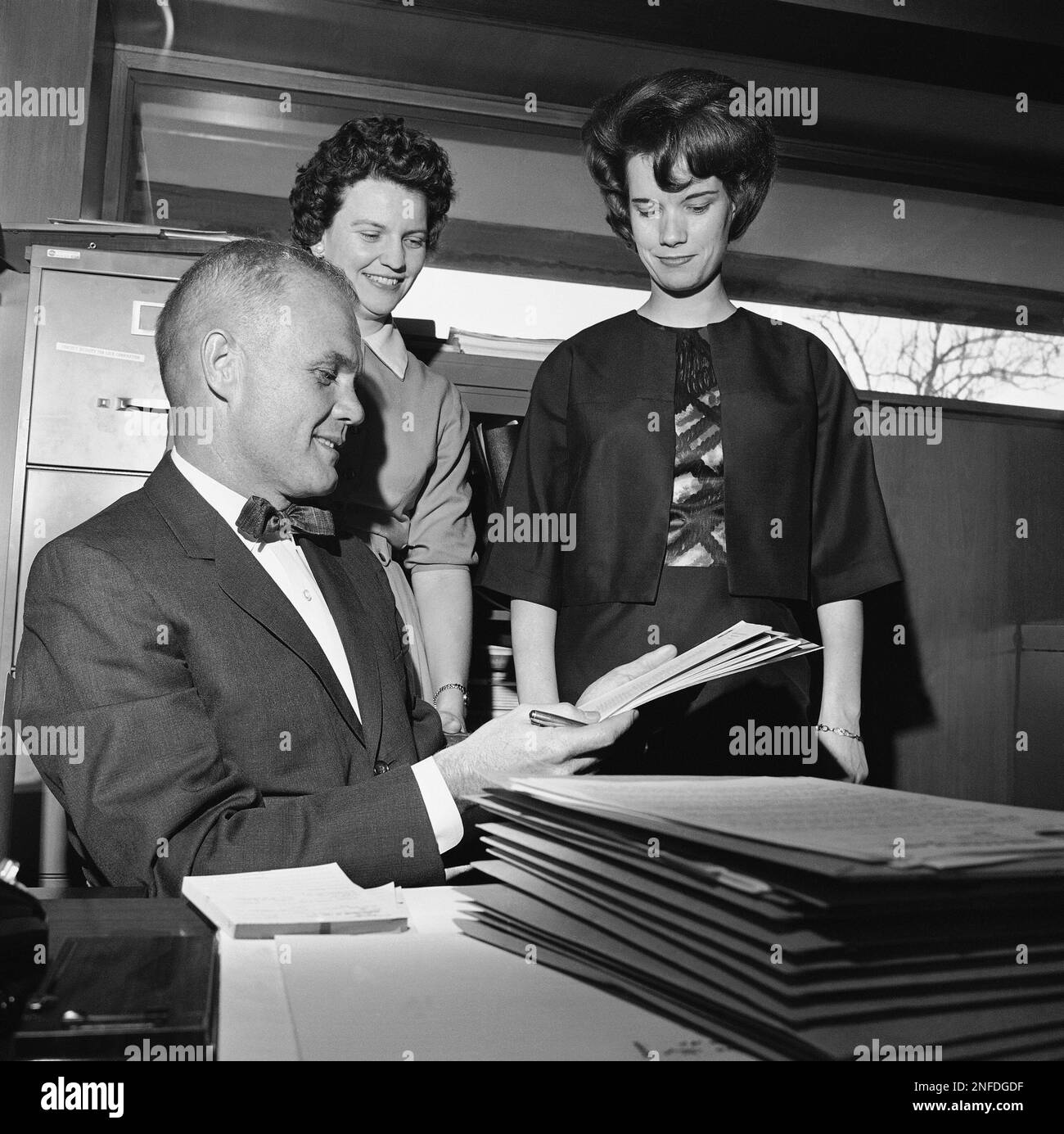 Astronaut John Glenn, left, goes over a letter with secretaries Mrs ...