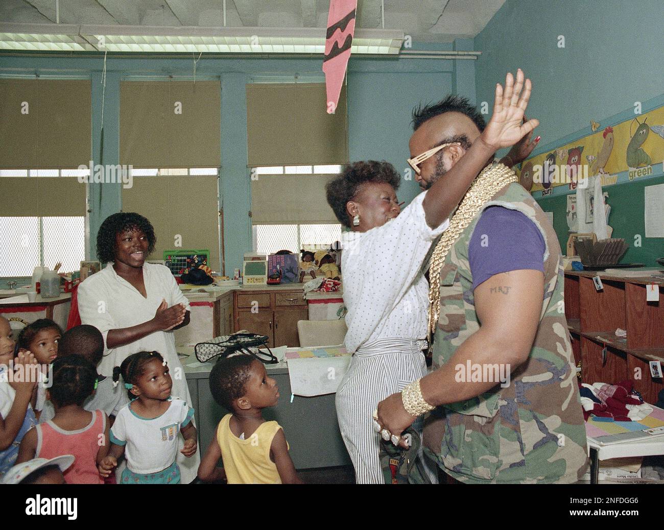 Day care teacher Kay Walden gives a hug to Mr. T as her students and ...