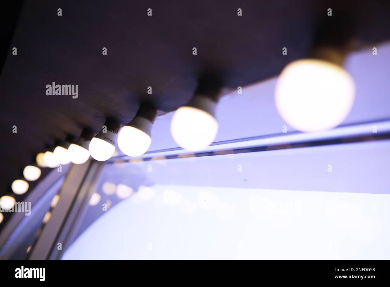 Circus lights in a row on red ceiling. Lamp hanging from the ceiling in ...