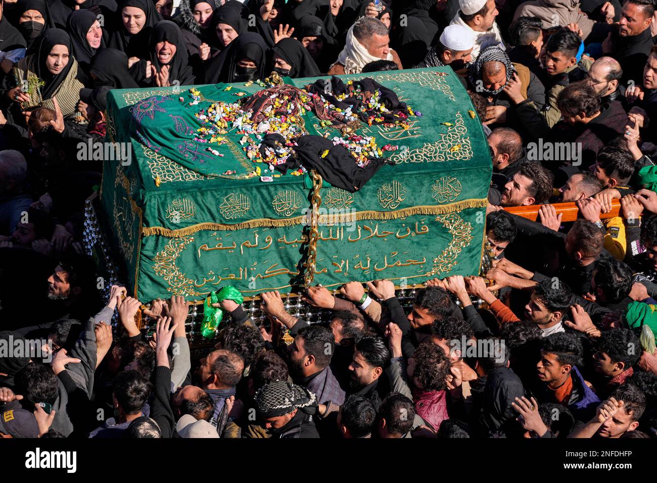 Shiite worshippers carry a symbolic coffin at the golden-domed shrine ...