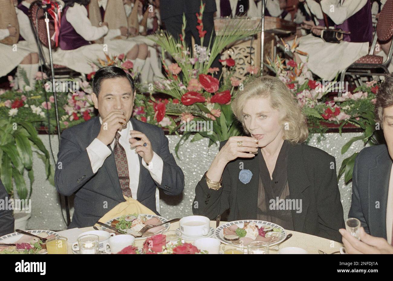 American actress Lauren Bacall receiving a toast from Lin Teng-fei ...
