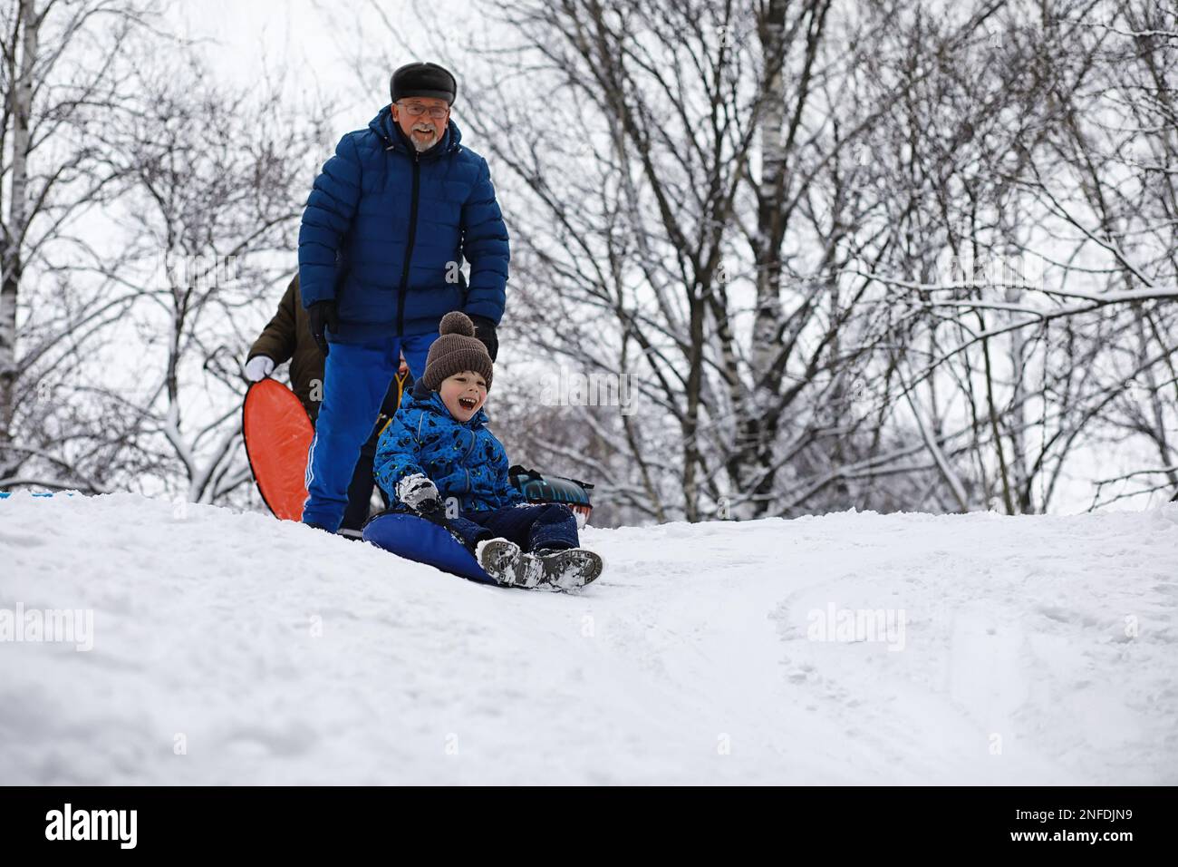 Children in the park in winter. Kids play with snow on playground. They ...