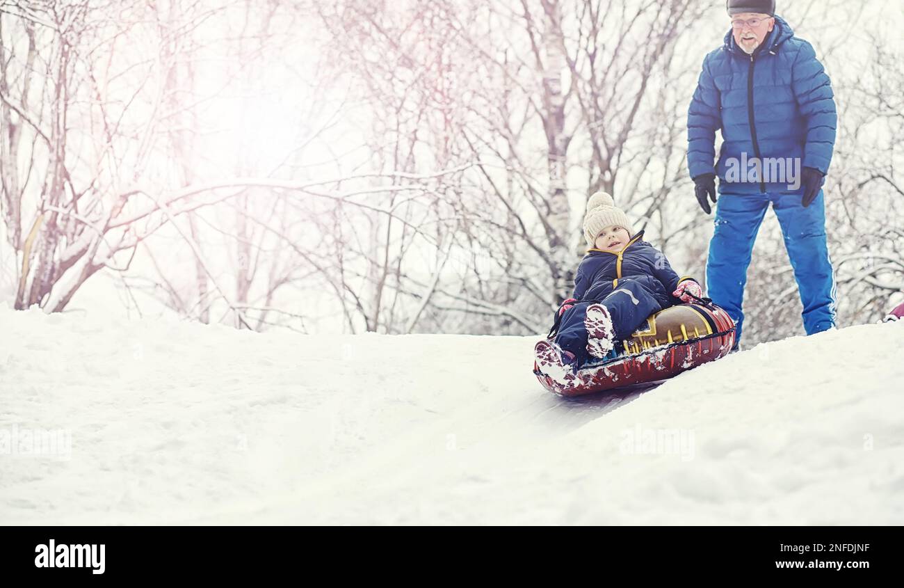 Children in the park in winter. Kids play with snow on playground. They ...