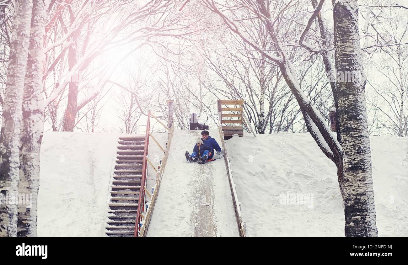 Children in the park in winter. Kids play with snow on playground. They ...
