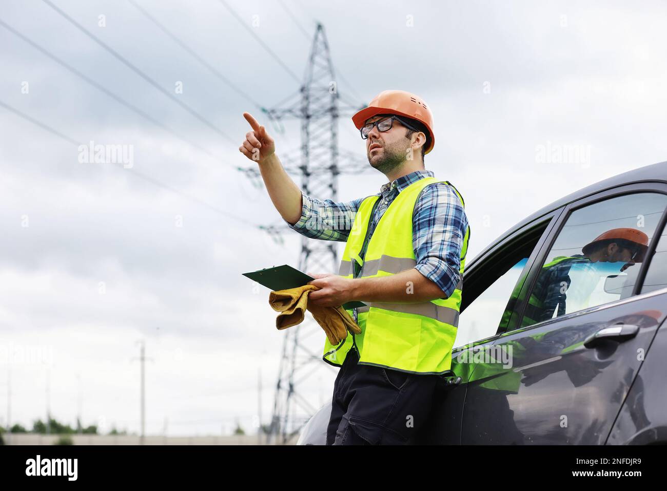 A man in a helmet and uniform, an electrician in the field ...