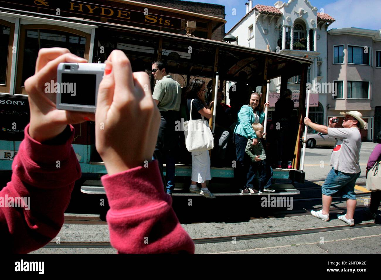 Passengers take pictures as they ride the Powell-Hyde cable car line in ...