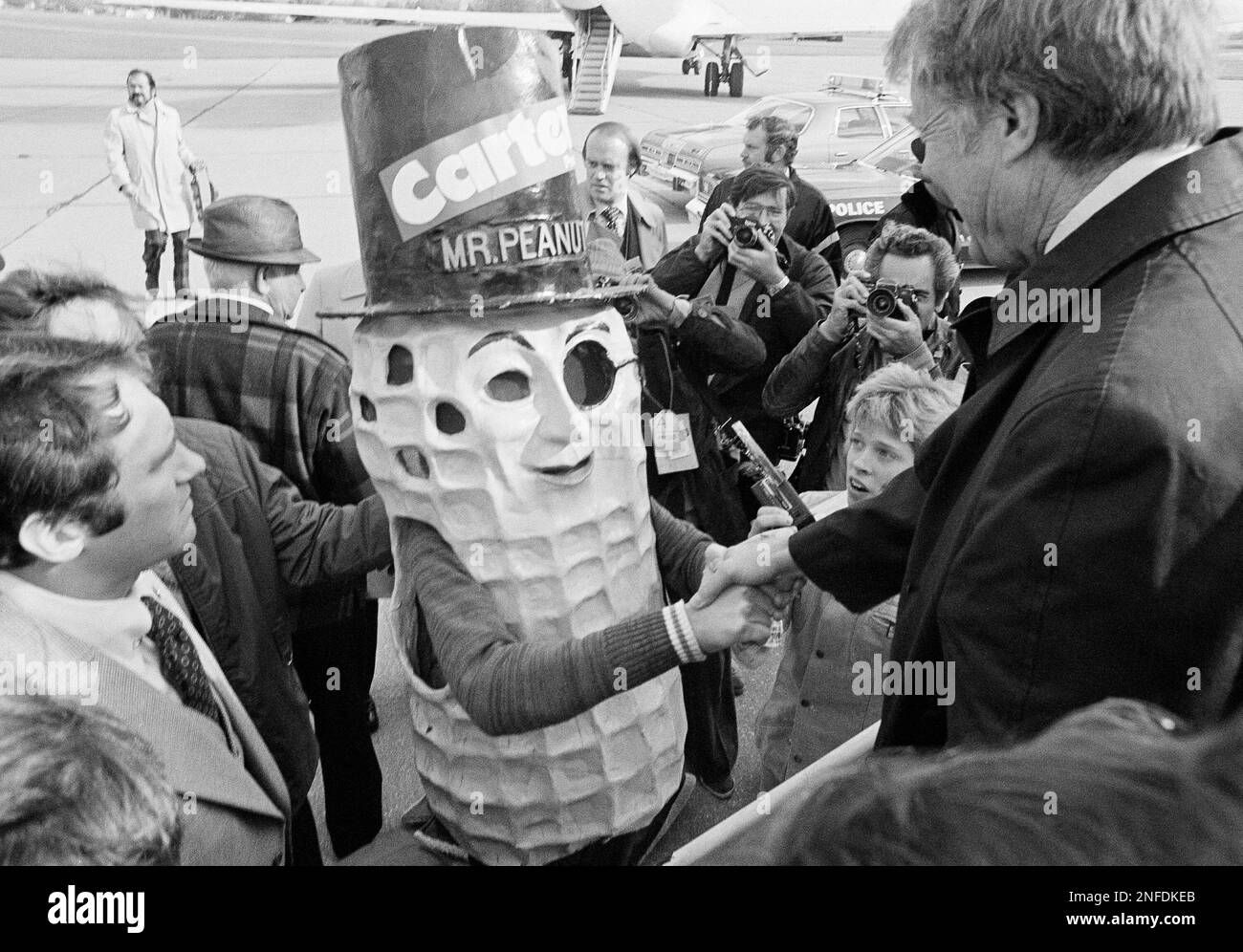 A person in a Mr. Peanut costume with a Carter sticker, draws a smile ...