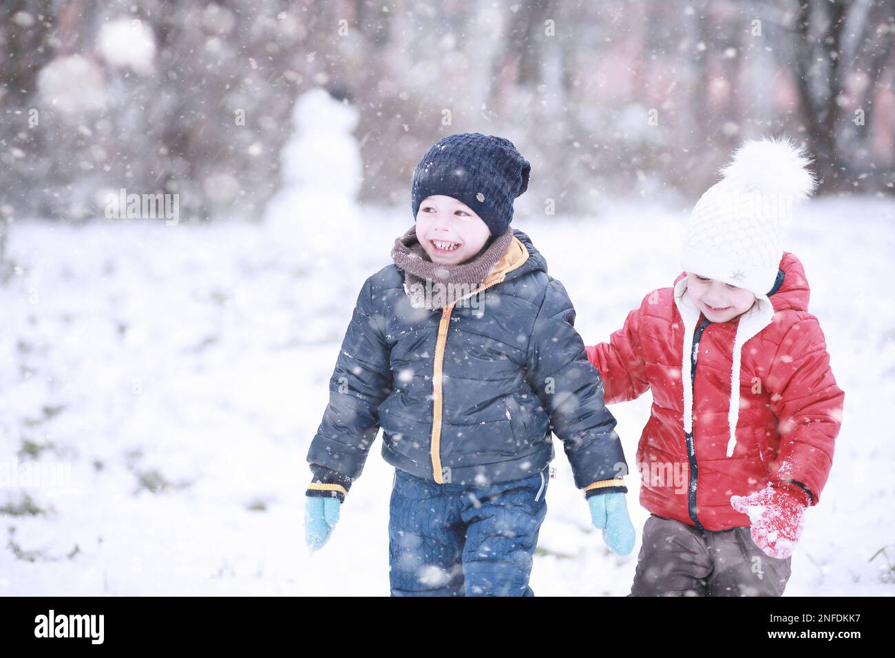 Kids walk in the park with first snow Stock Photo - Alamy