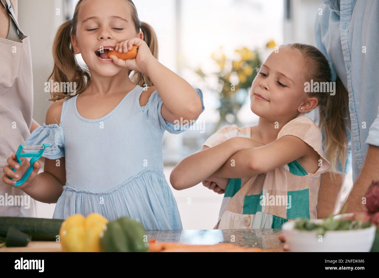 Children, cooking and a girl eating a carrot in the kitchen while ...
