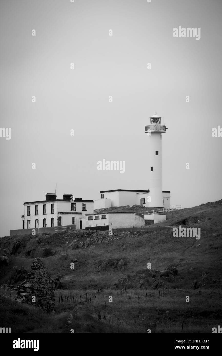 A vertical grayscale shot of Inishtrahull Lighthouse on gloomy day in ...