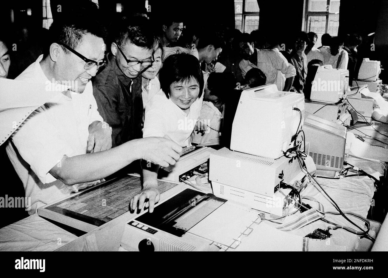 Technicians examine a compact Chinese language computer, suitable for ...