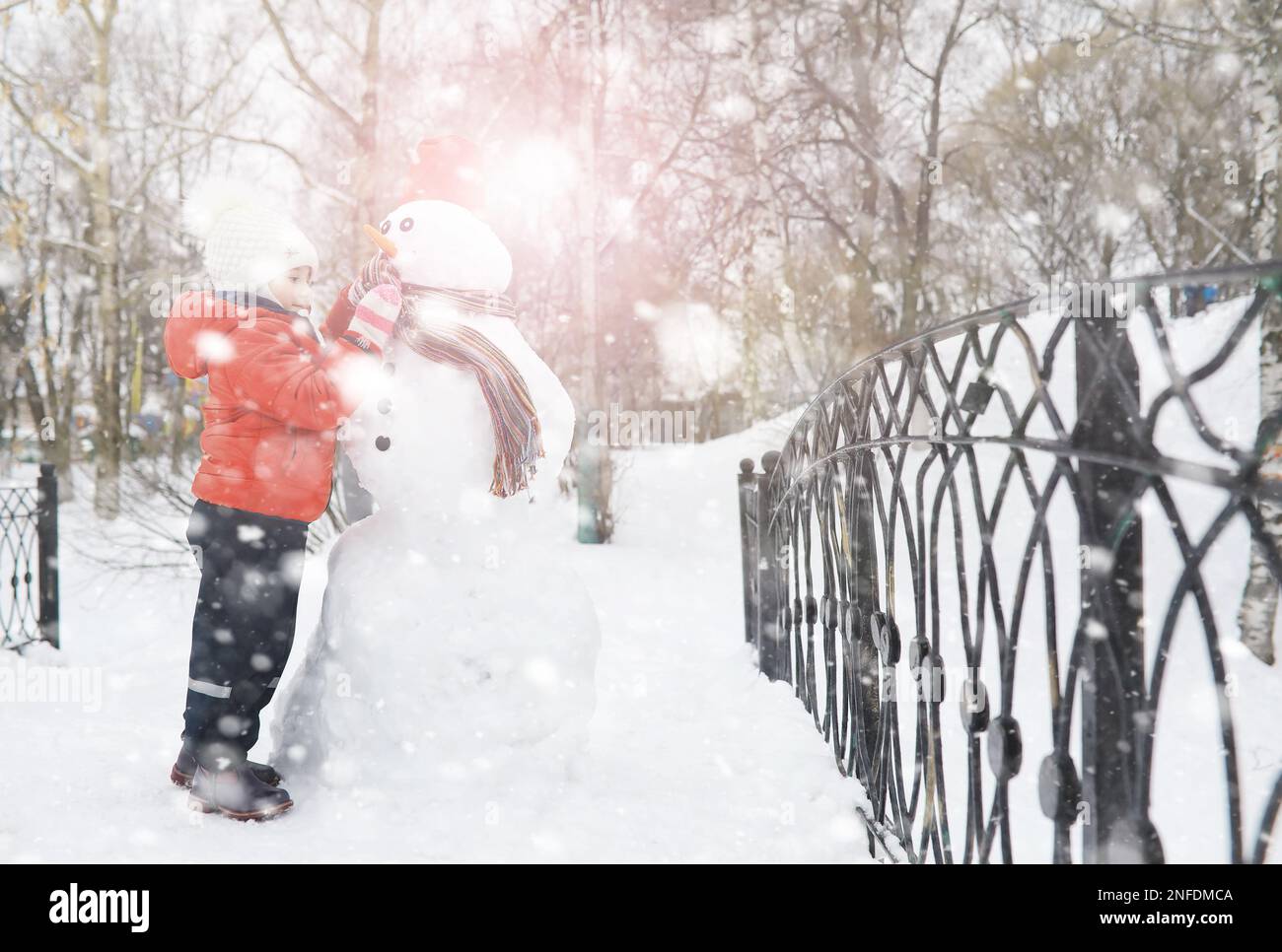 Children in the park in winter. Kids play with snow on the playground ...