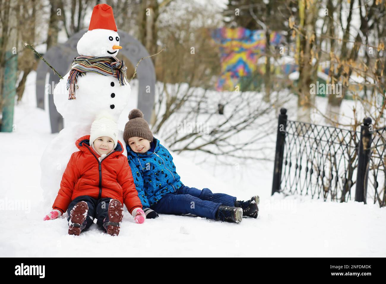 Children in the park in winter. Kids play with snow on the playground ...