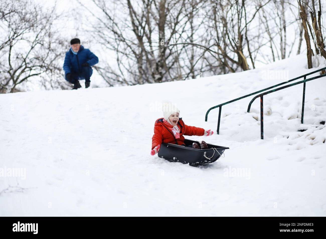 Children in the park in winter. Kids play with snow on the playground ...
