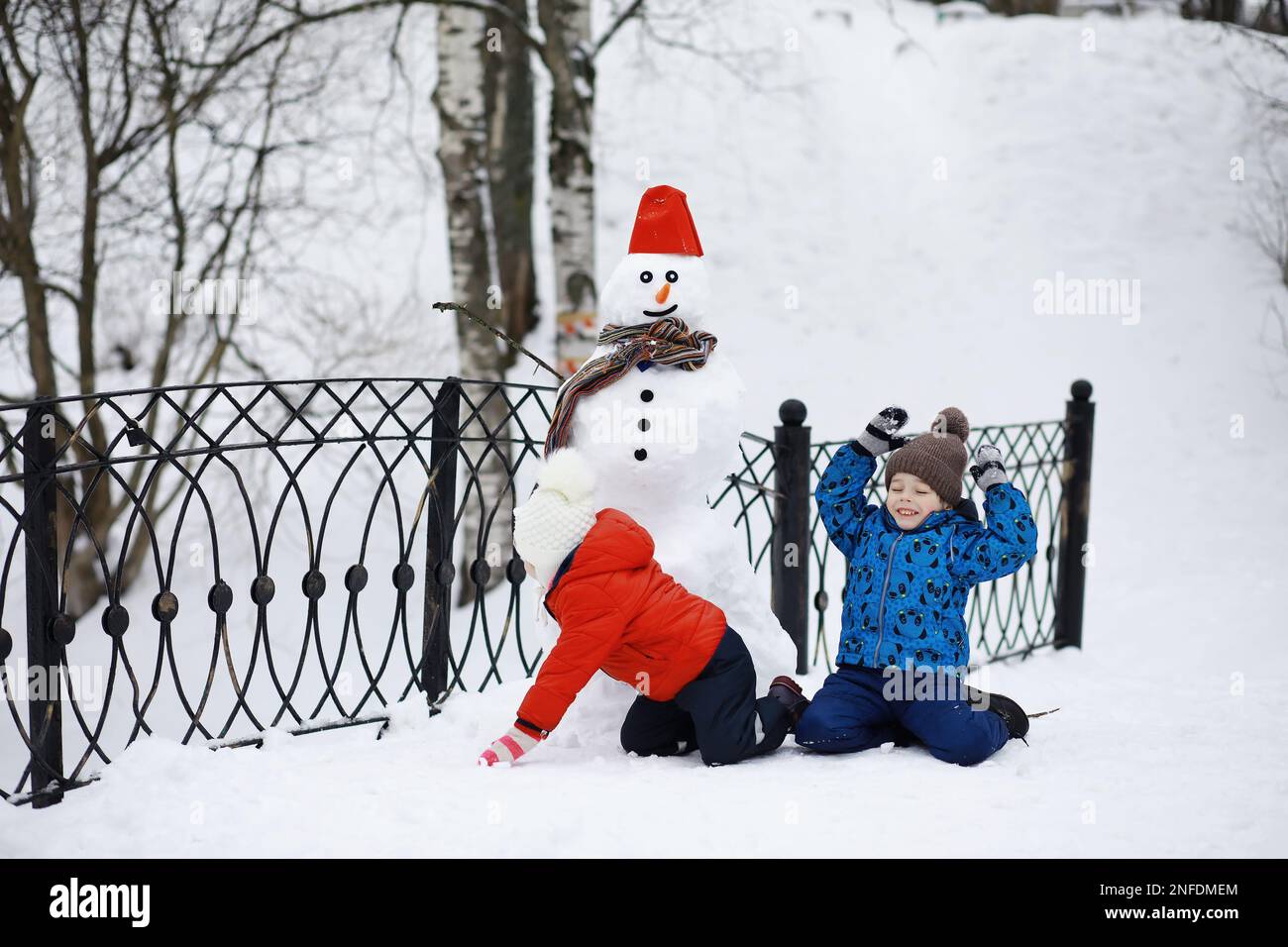 Children in the park in winter. Kids play with snow on the playground ...