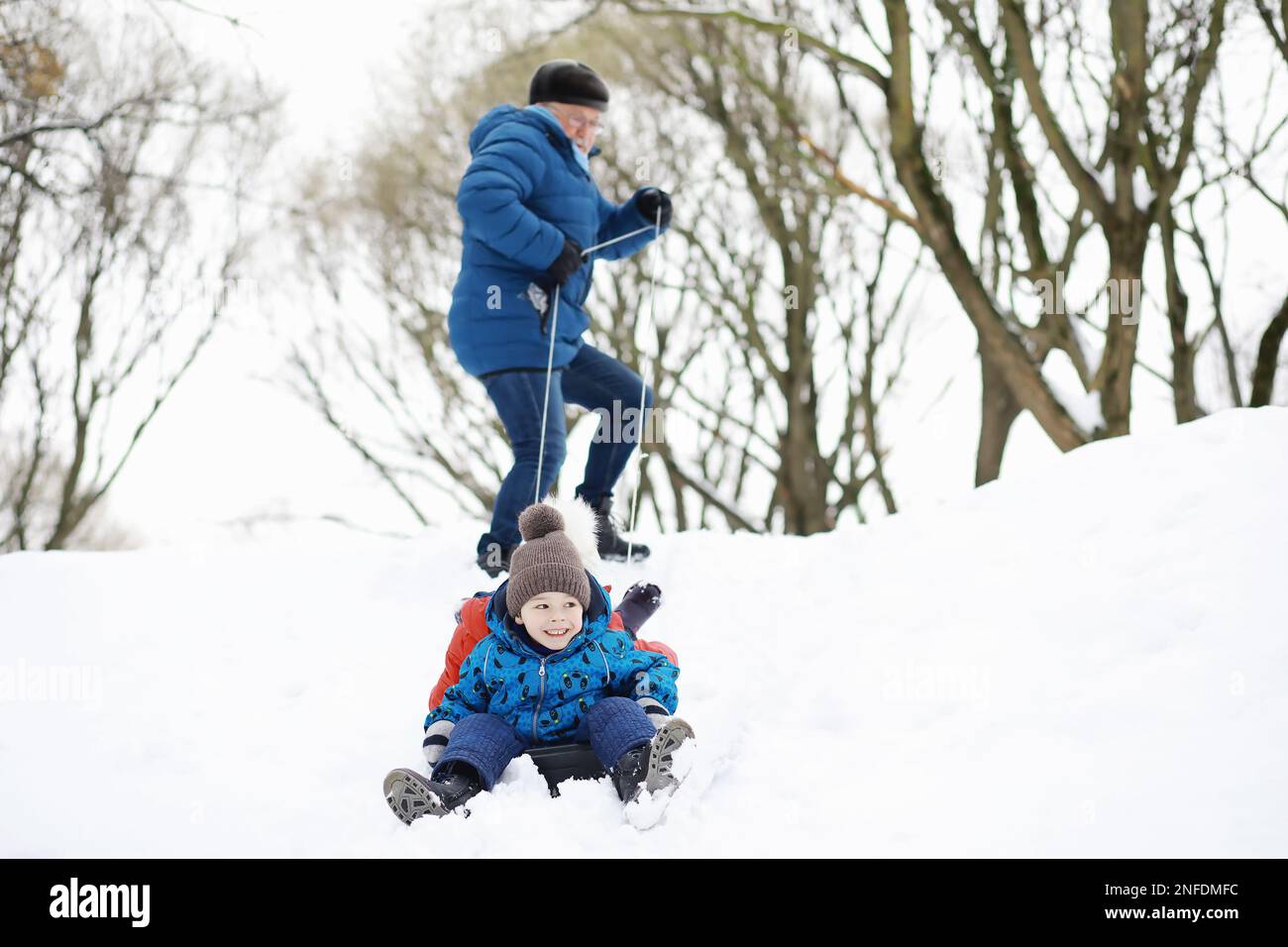 Children in the park in winter. Kids play with snow on the playground ...