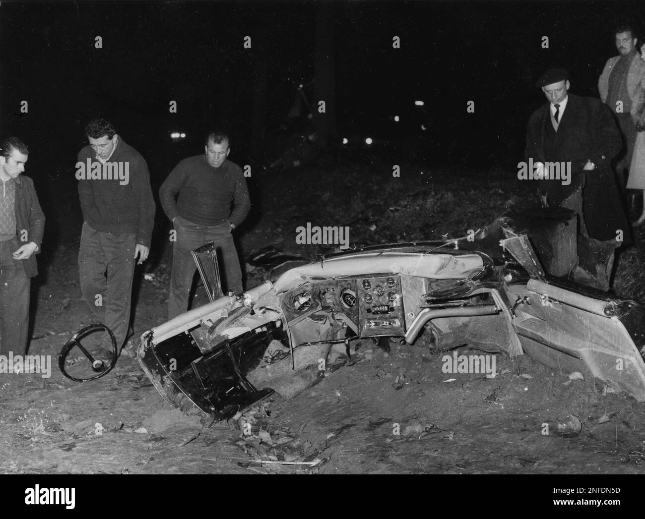 Unidentified people stand around the front section and dashboard of the ...