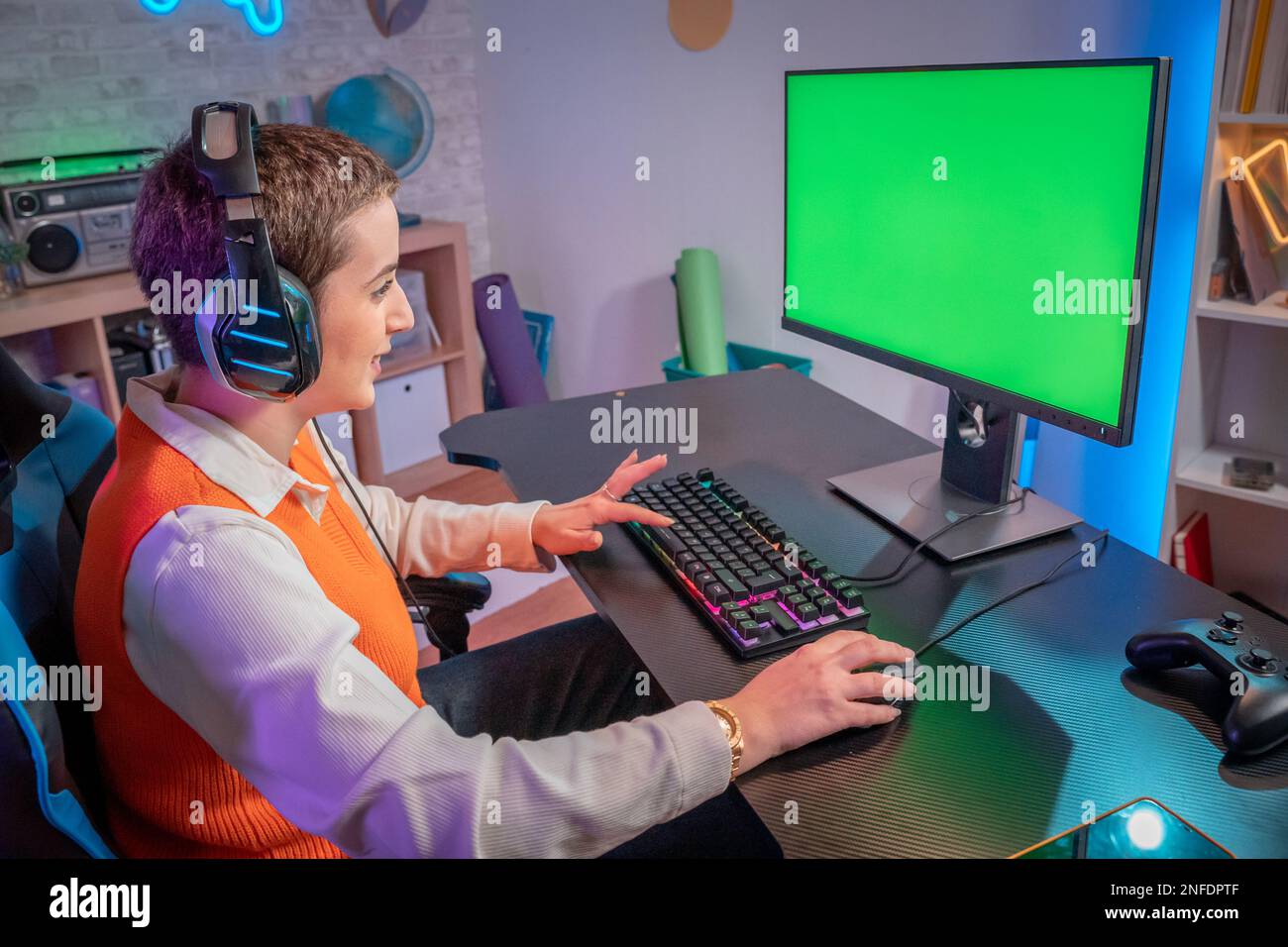 Pro gamer streaming video games with green screen mockup display in ...