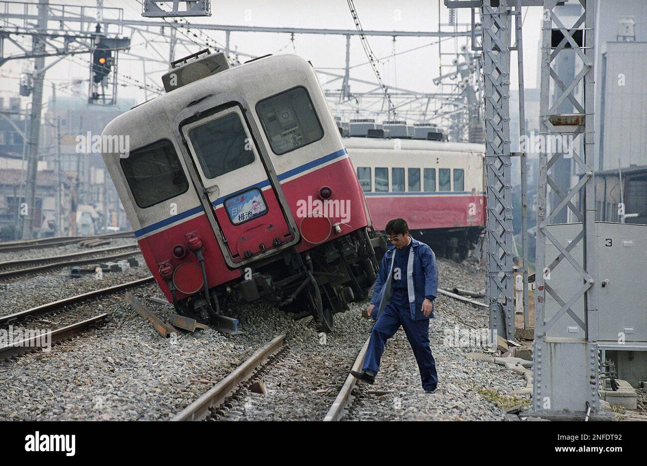 A Japan Railways commuter train lies between tracks in Nishinomiya ...