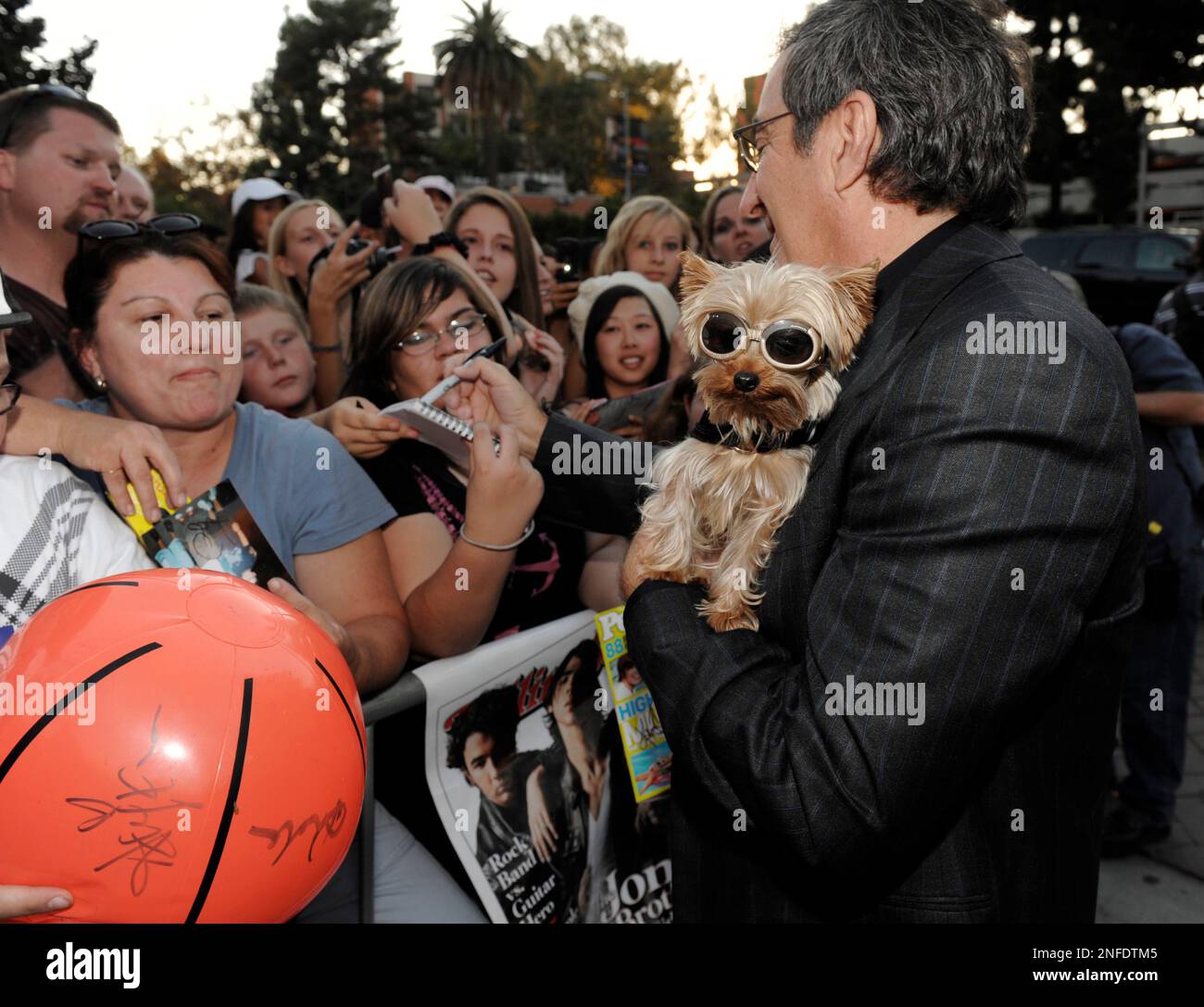 Director Kenny Ortega holds his dog Manley as he signs autographs at ...