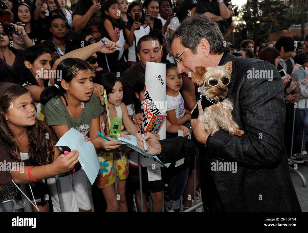 Director Kenny Ortega holds his dog Manley as he signs autographs at ...