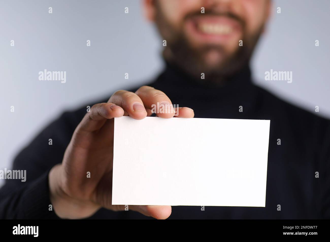 a small white piece of paper in his hand man Stock Photo - Alamy
