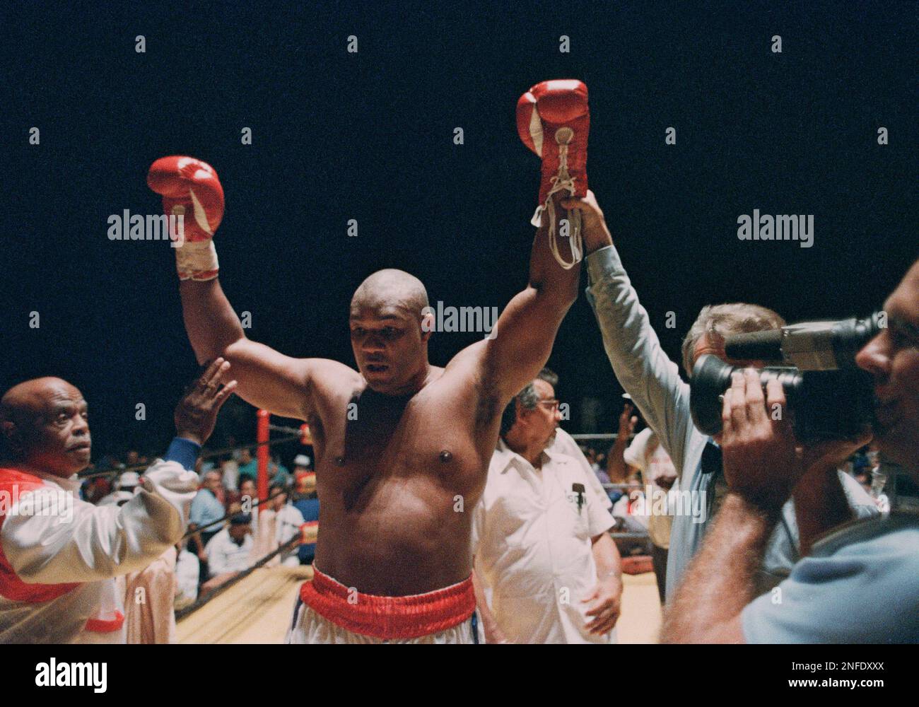 Former heavyweight champion George Foreman, center, holds his arms in ...