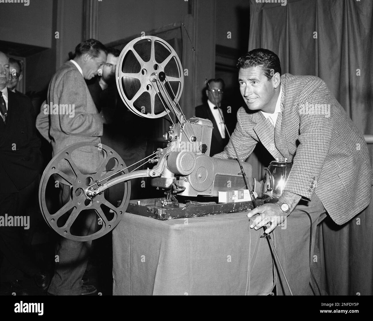 Boston Red Sox slugger Ted Williams, right, lines up a movie projector ...