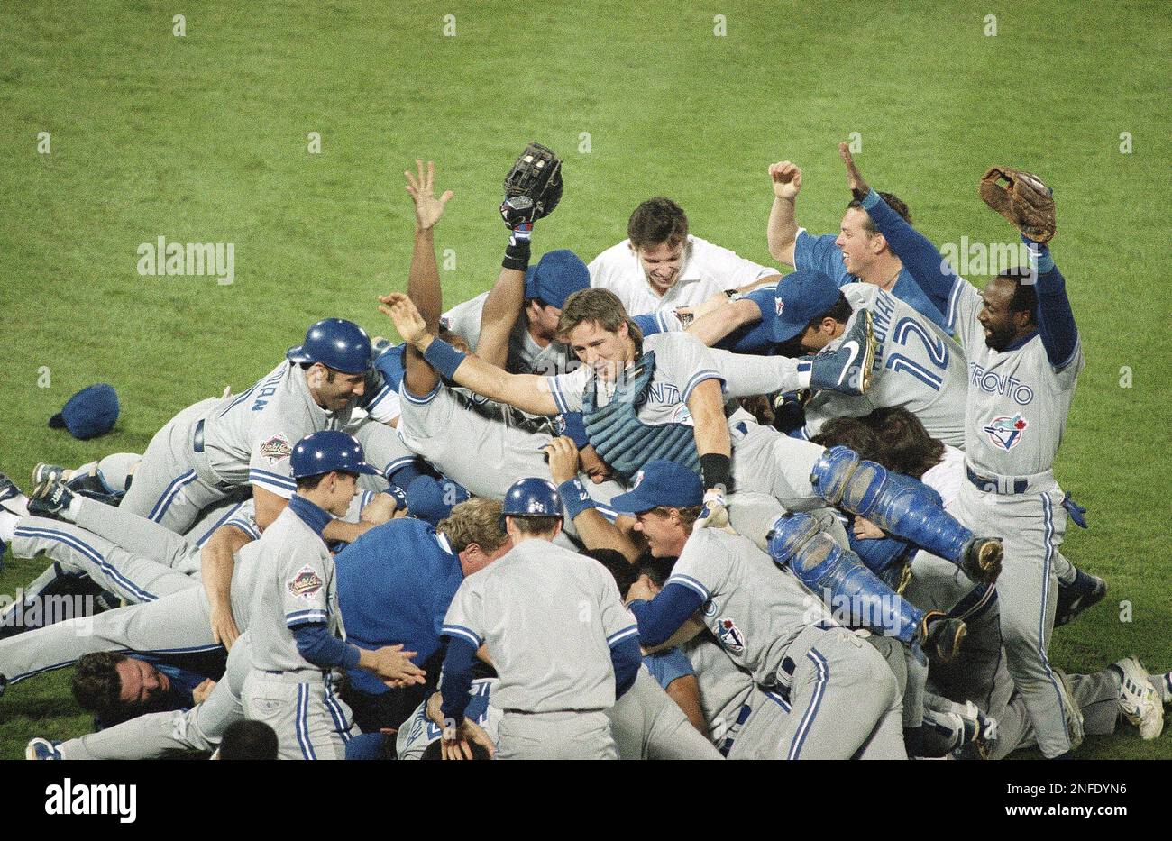Toronto Blue Jays MVP Pat Borders, wearing catchers equipment, piles on ...