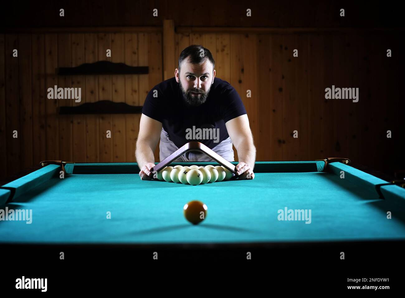 A man with a beard plays a big billiard. Party in 12-foot pool ...