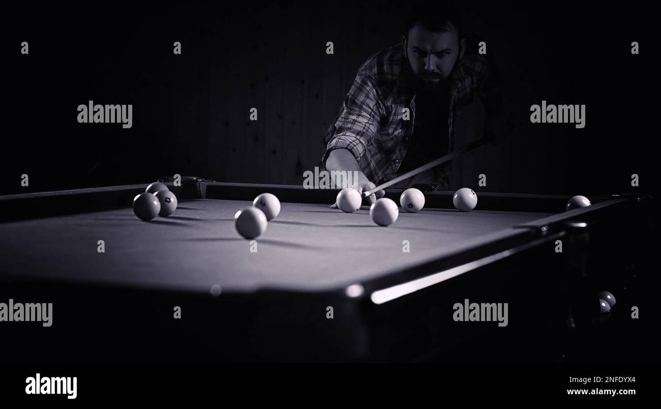 A man with a beard plays a big billiard. Party in 12-foot pool ...