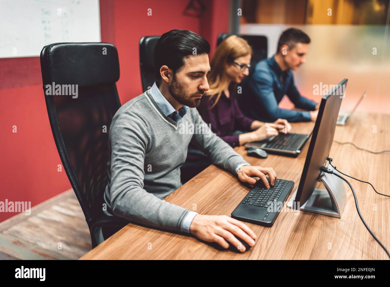Group of people at a start up company working on their computers ...