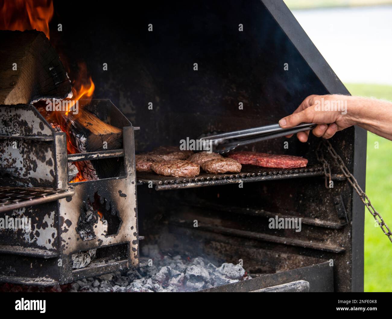 grilling meat on a wood fired barbecue with an open fire Stock Photo ...