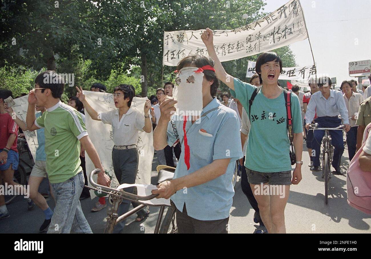 A masked protester from Beijing University leads chants making fun of ...