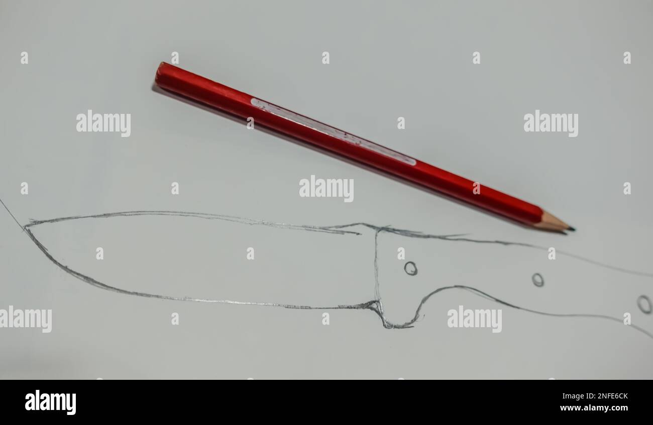 drawing from a knive and with a pencil on a gray sheet in a workshop ...