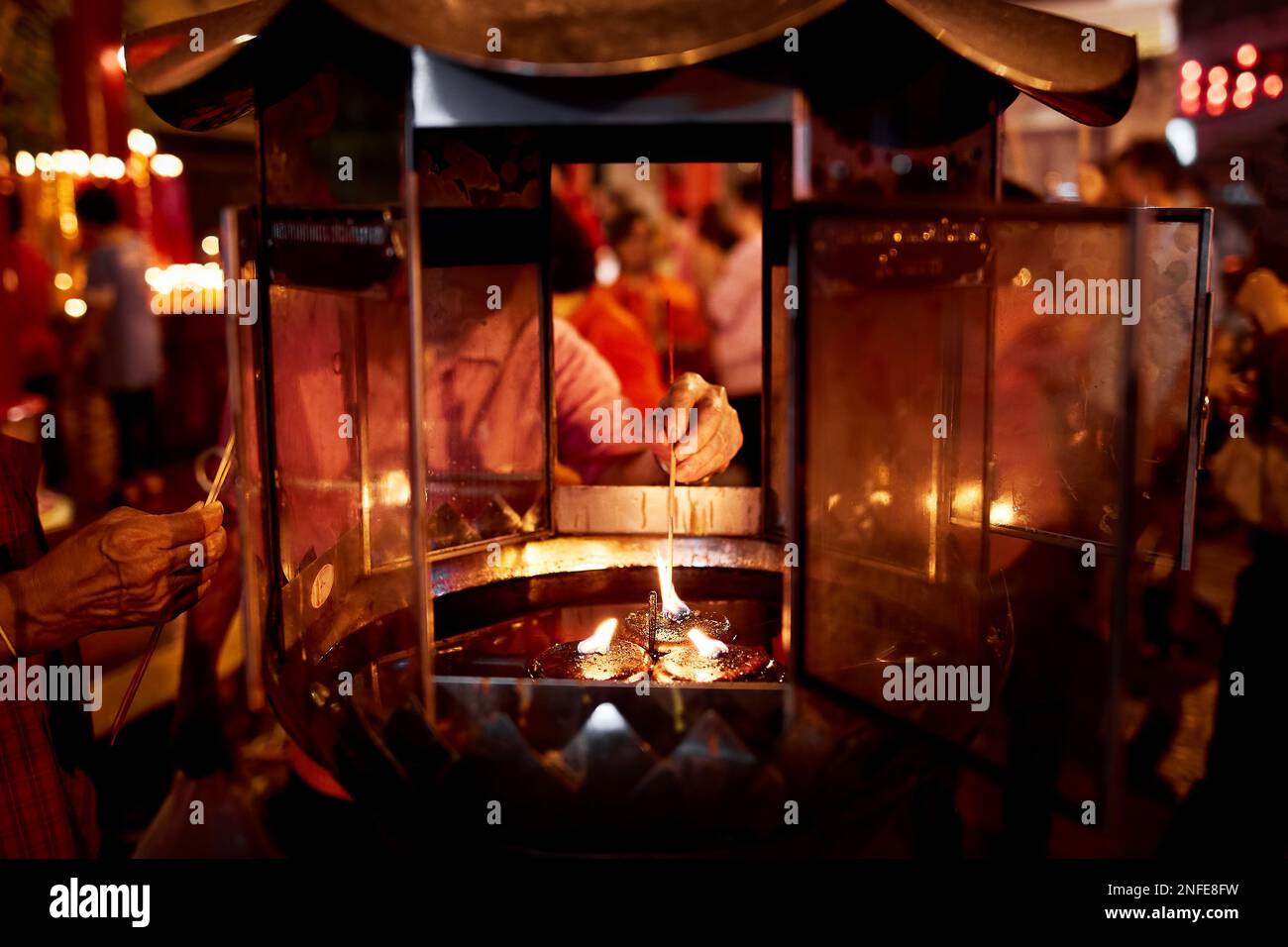 People burning incense from candle fire in the temple at Chinese New ...