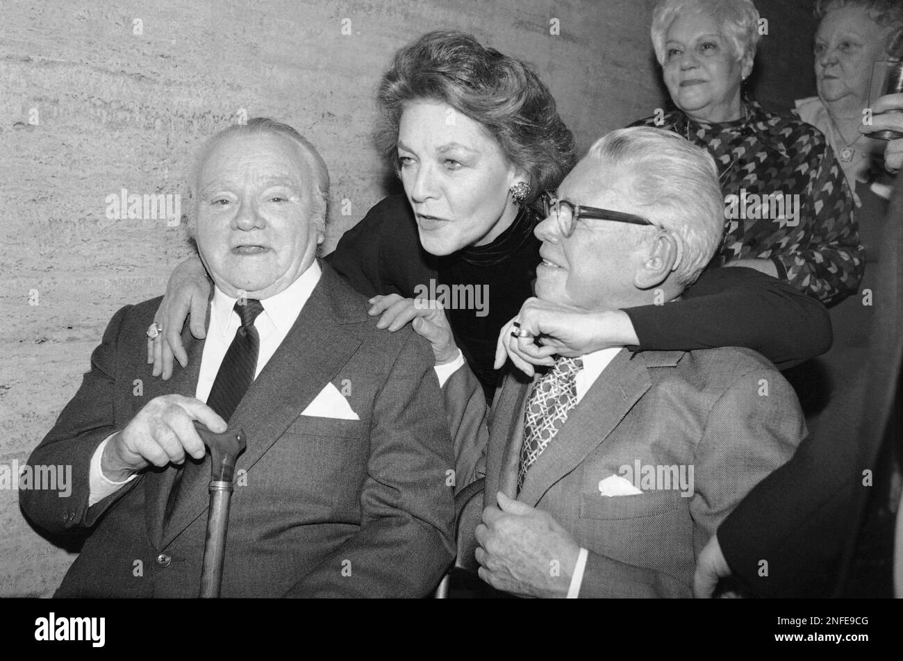 Actress Lauren Bacall puts her arms around actor James Cagney, left ...