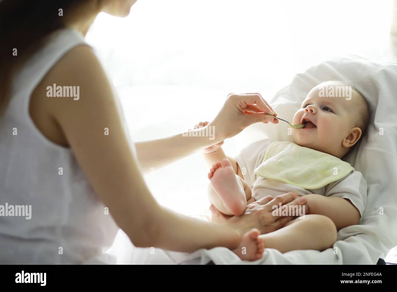 Maternity concept. A young mother feeds her little baby. First lure and ...