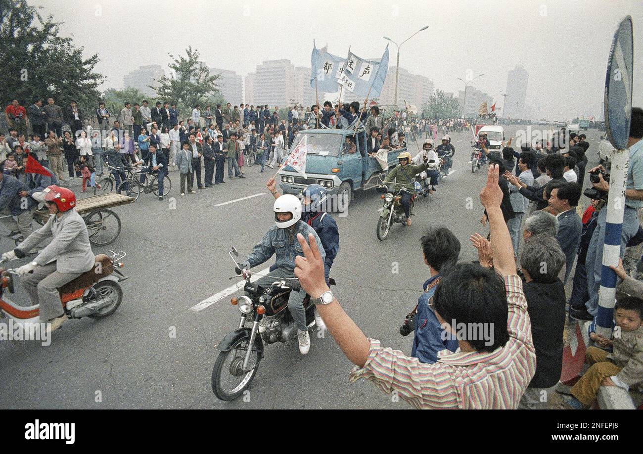 Pedestrians cheer on demonstrators for democracy as they parade to ...