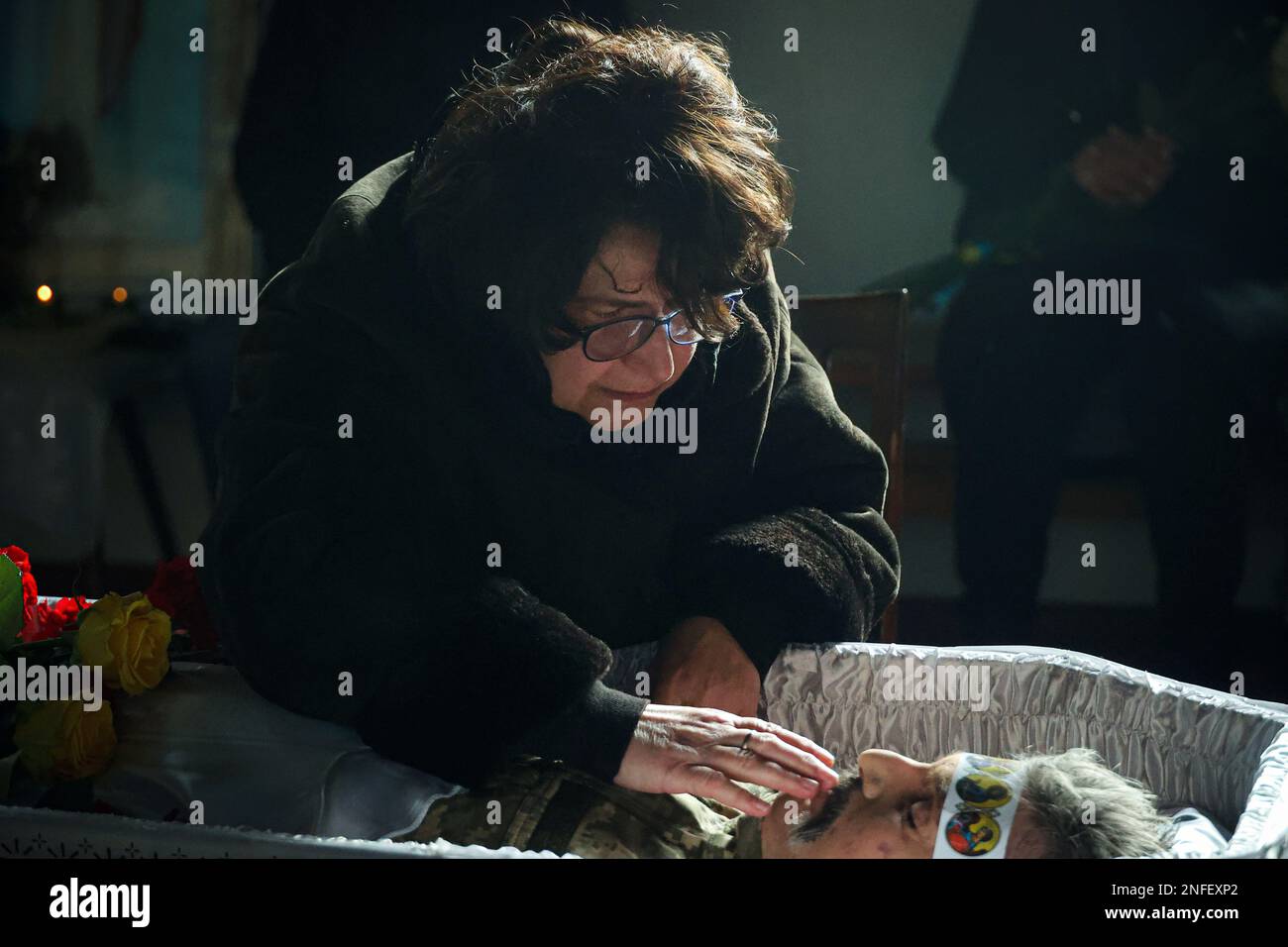 KHARKIV, UKRAINE - FEBRUARY 16, 2023 - A woman mourns by the body of ...