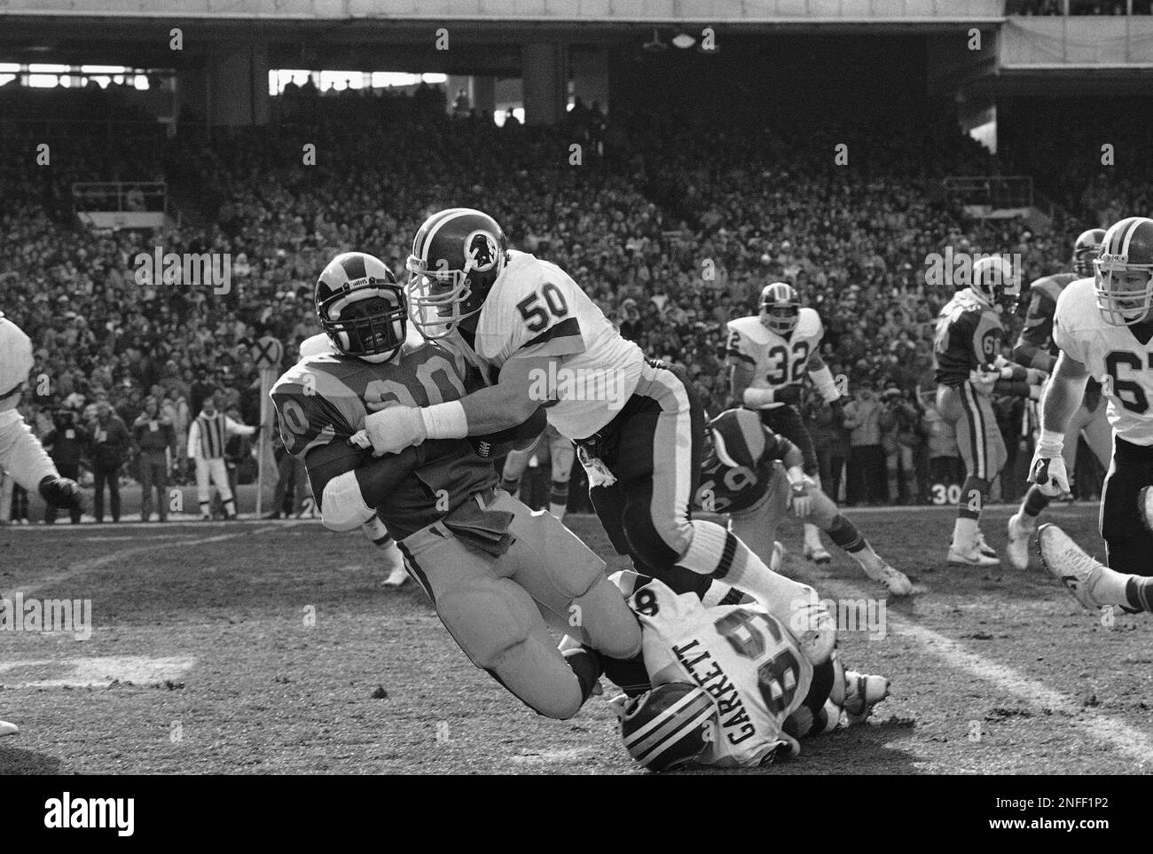 Los Angeles Rams wide receiver Henry Ellard is brought down by Redskins ...
