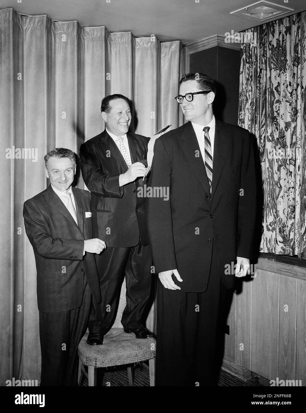 Big George Mikan, coach of the Minneapolis Lakers, is the tall man who ...