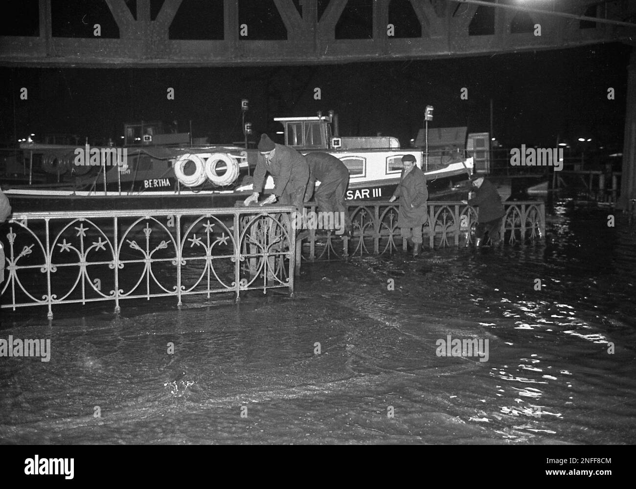 Pedestrians use a guard-rail to bypass the flooded streets of Hamburg ...