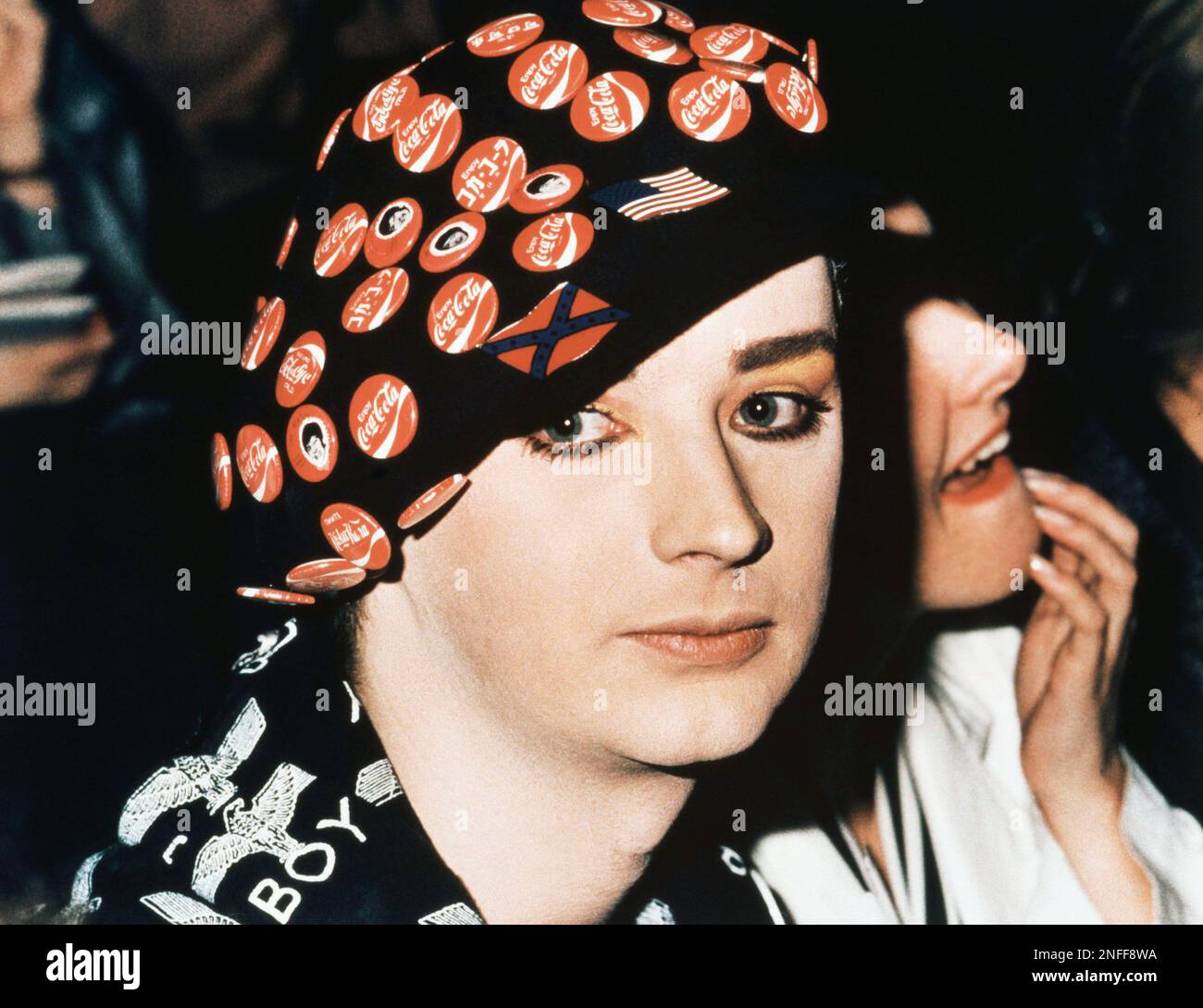British pop star Boy George sports a cap covered with button and pins ...