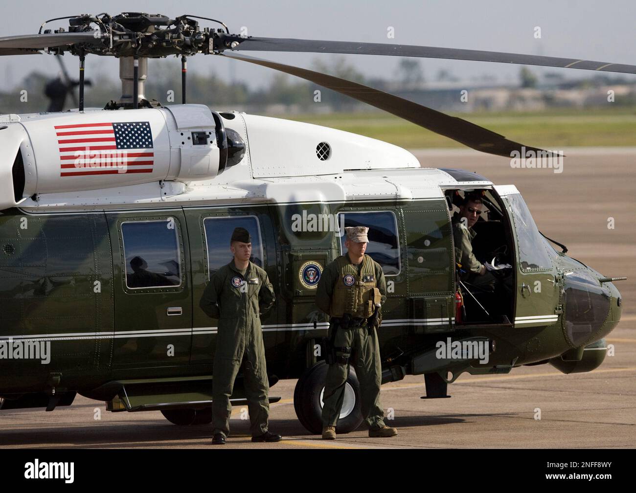 The crew of Marine One stand at attention as Air Force One arrives at ...