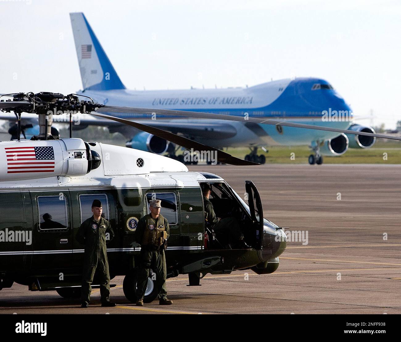 The crew of Marine One stand at attention as Air Force One arrives at ...