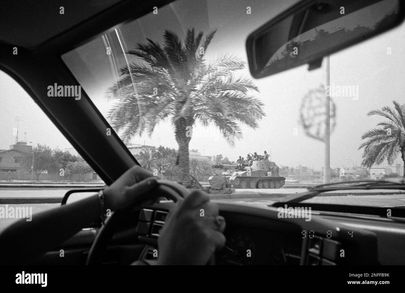 Iraqi soldiers ride on top of one of their tanks through the streets of ...